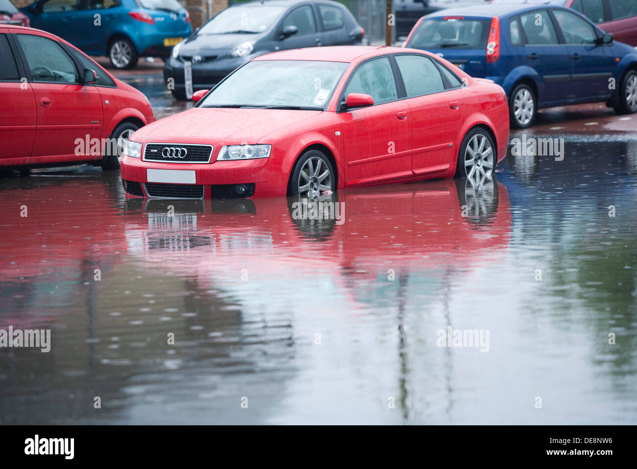 Red car sitting in a flooded car park Stock Photo - Alamy