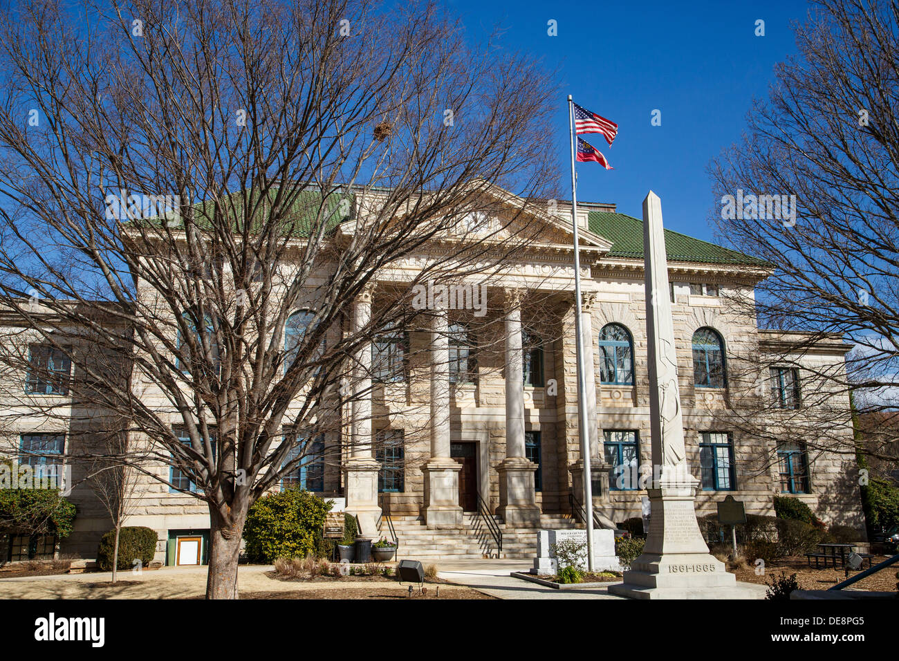 An old stone courthouse with American and Georgia Flags Under clear ...