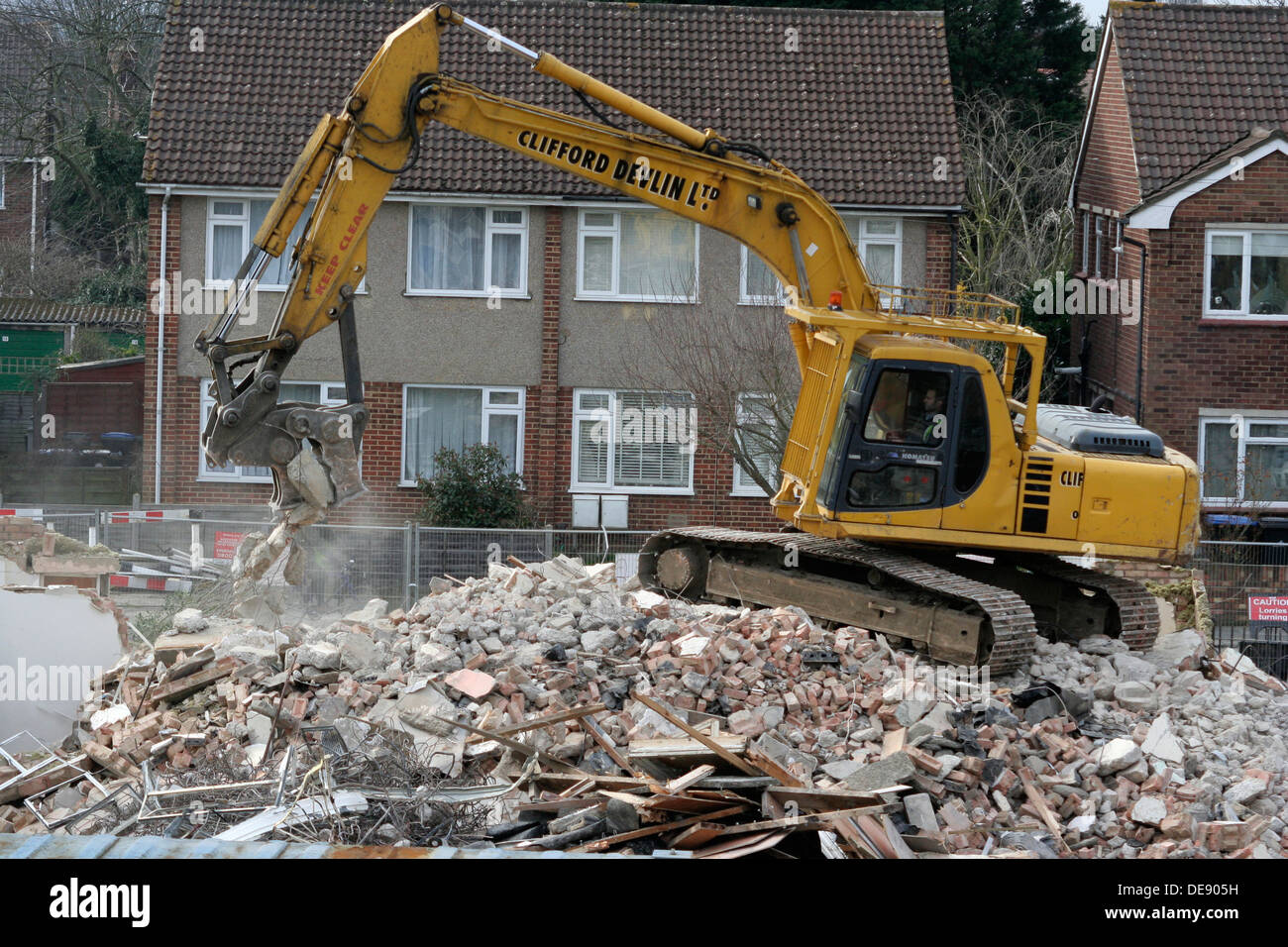 The Demolition of a Small block of Flats using an excavator. Crushing ...