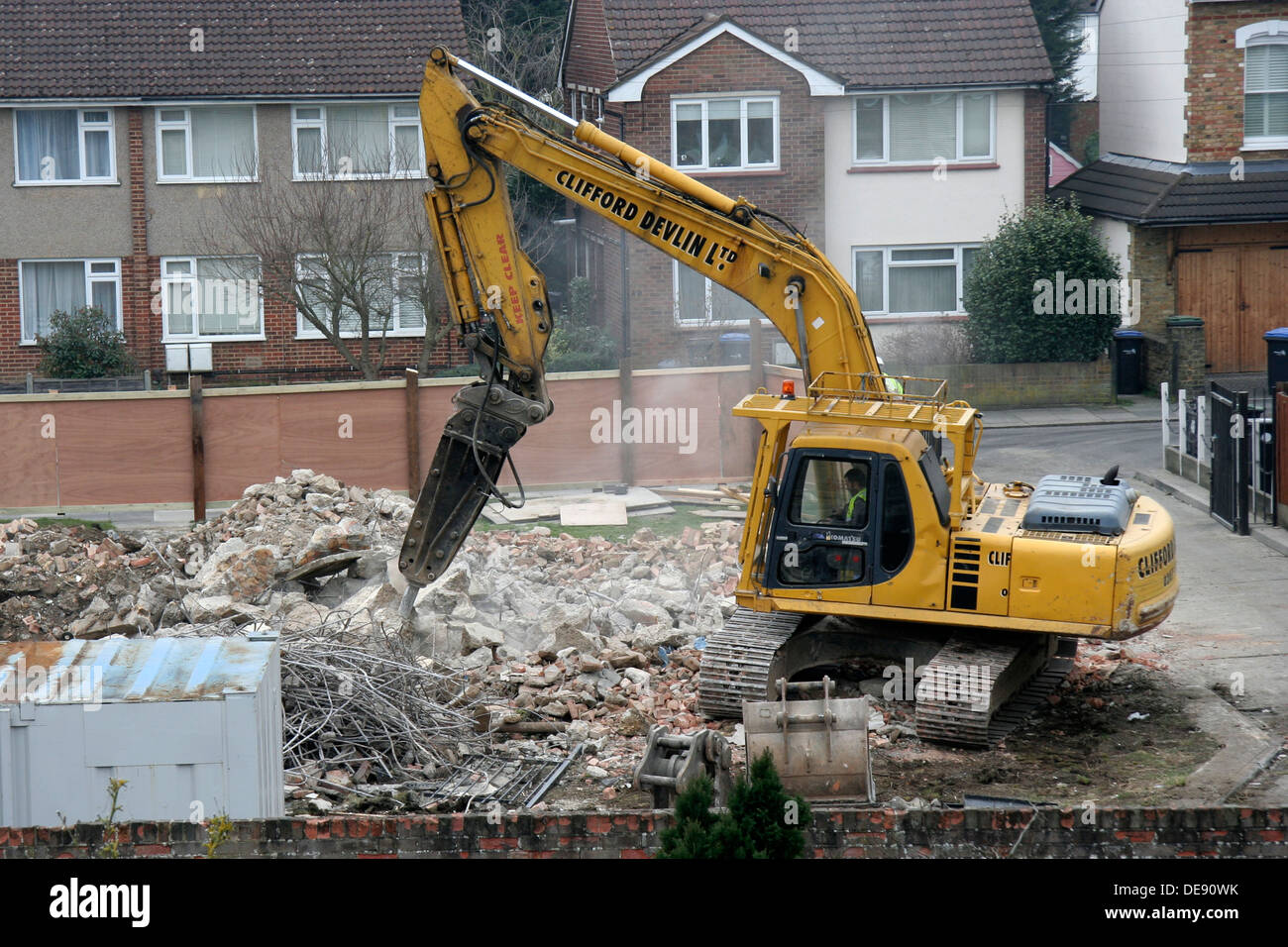 The Demolition of a Small block of Flats using an excavator. Breaking ...