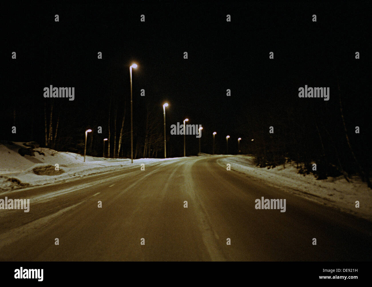 Empty Road Lined with Street Lights at Night in Winter Stock Photo - Alamy