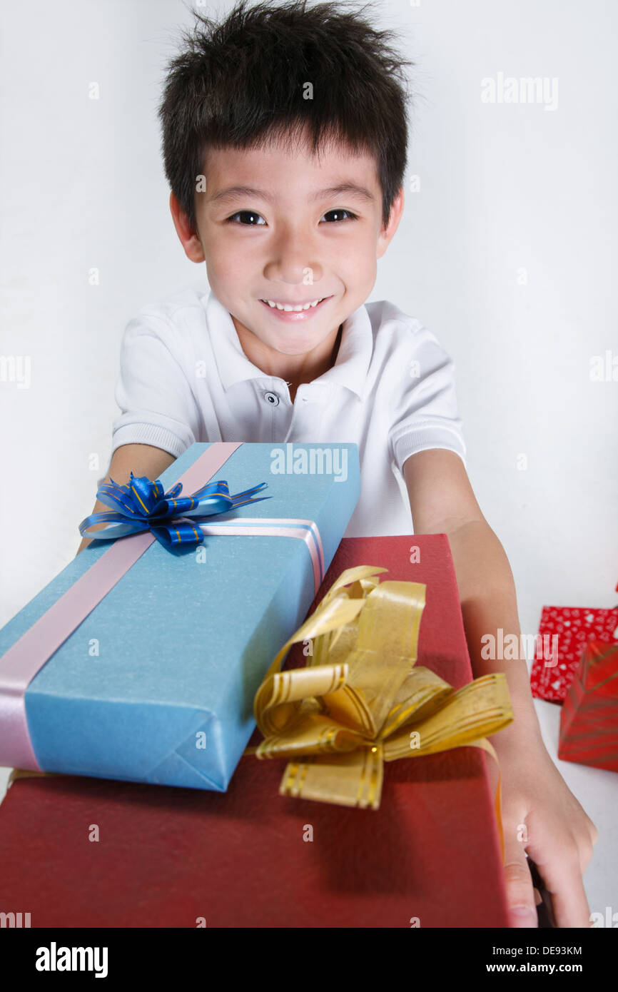 Boy holding gift boxes Stock Photo - Alamy