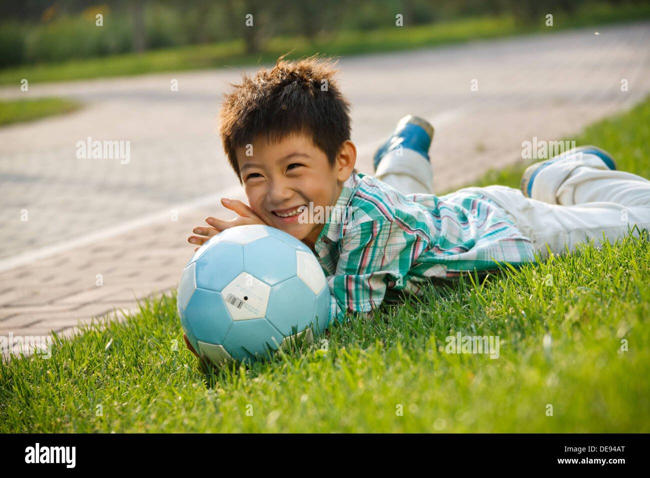Boy lying on ground Stock Photo - Alamy