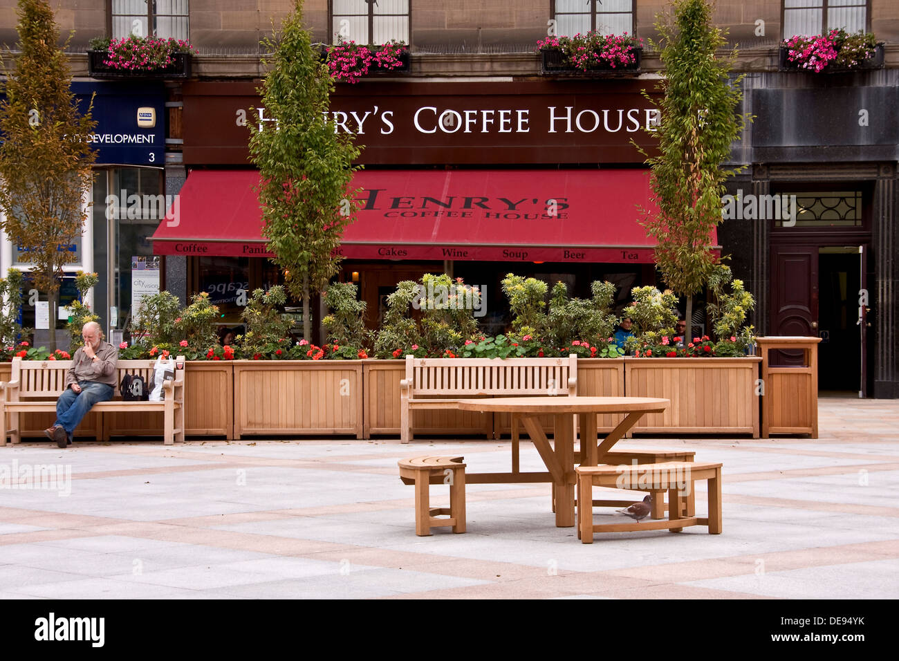 Man sitting eating outside at the City Square while people enjoying ...