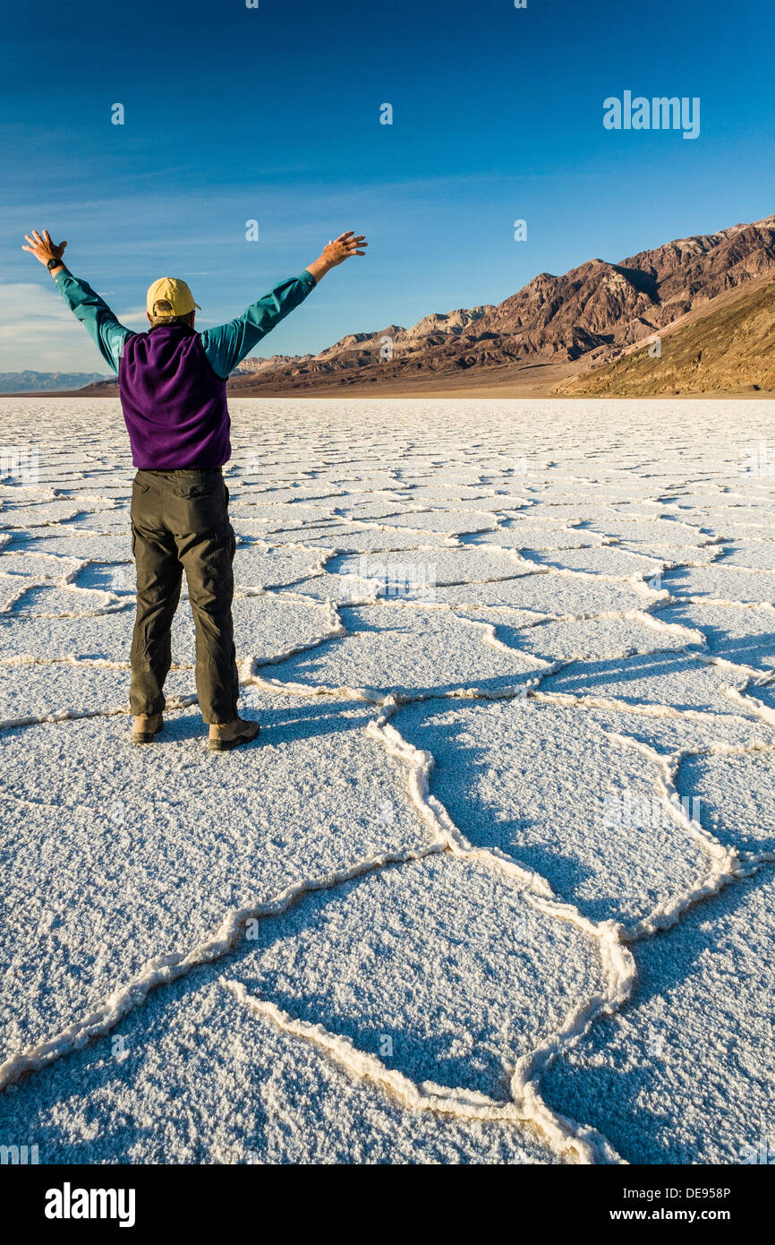 A man with outstretched arms stands in the geometric patterns of ...