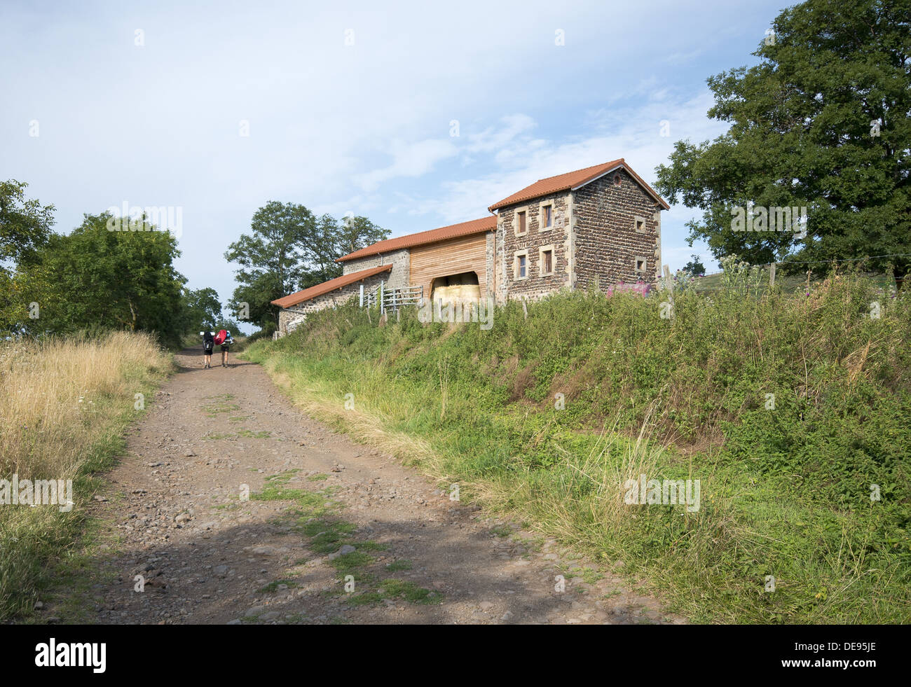 Pilgrims walking past farmhouse on the GR65 walking route the Way of St ...
