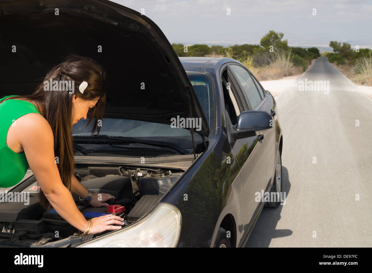 Hispanic female trying to fix her cars breakdown Stock Photo - Alamy