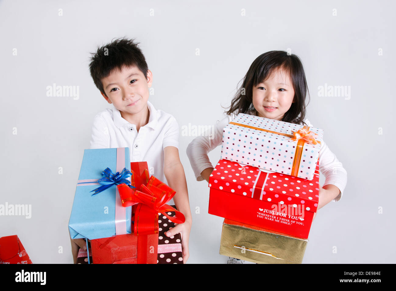 Boy and girl holding gift boxes Stock Photo - Alamy