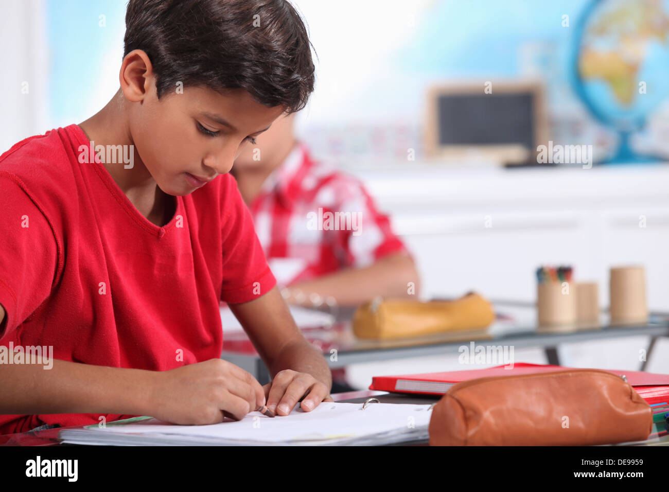 little boy focusing on his work in classroom Stock Photo - Alamy