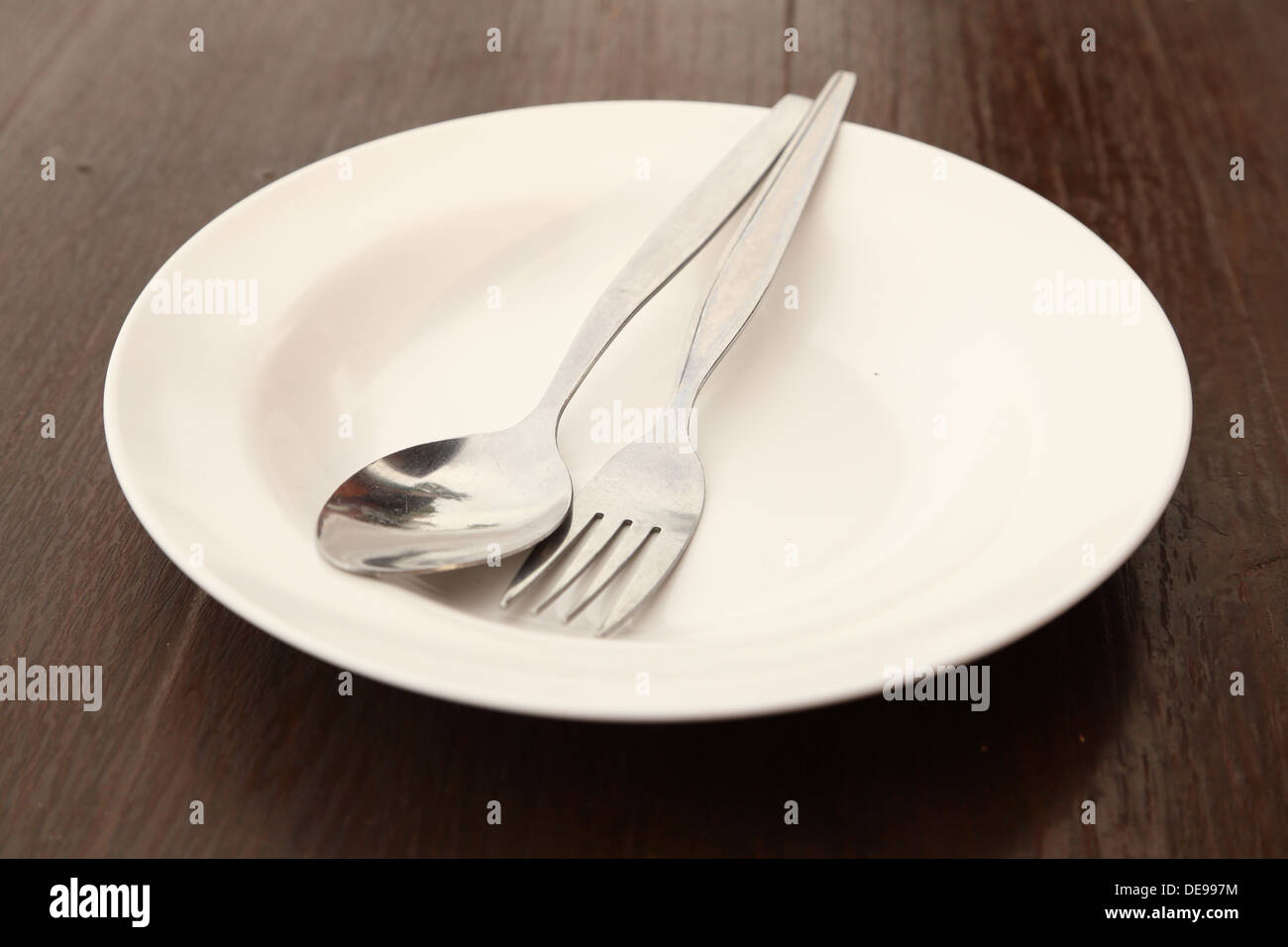 Silverware and plate on wood table Stock Photo - Alamy