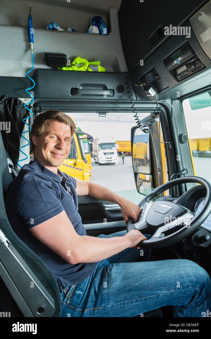 Logistics - proud driver or forwarder in drivers cap of truck and ...