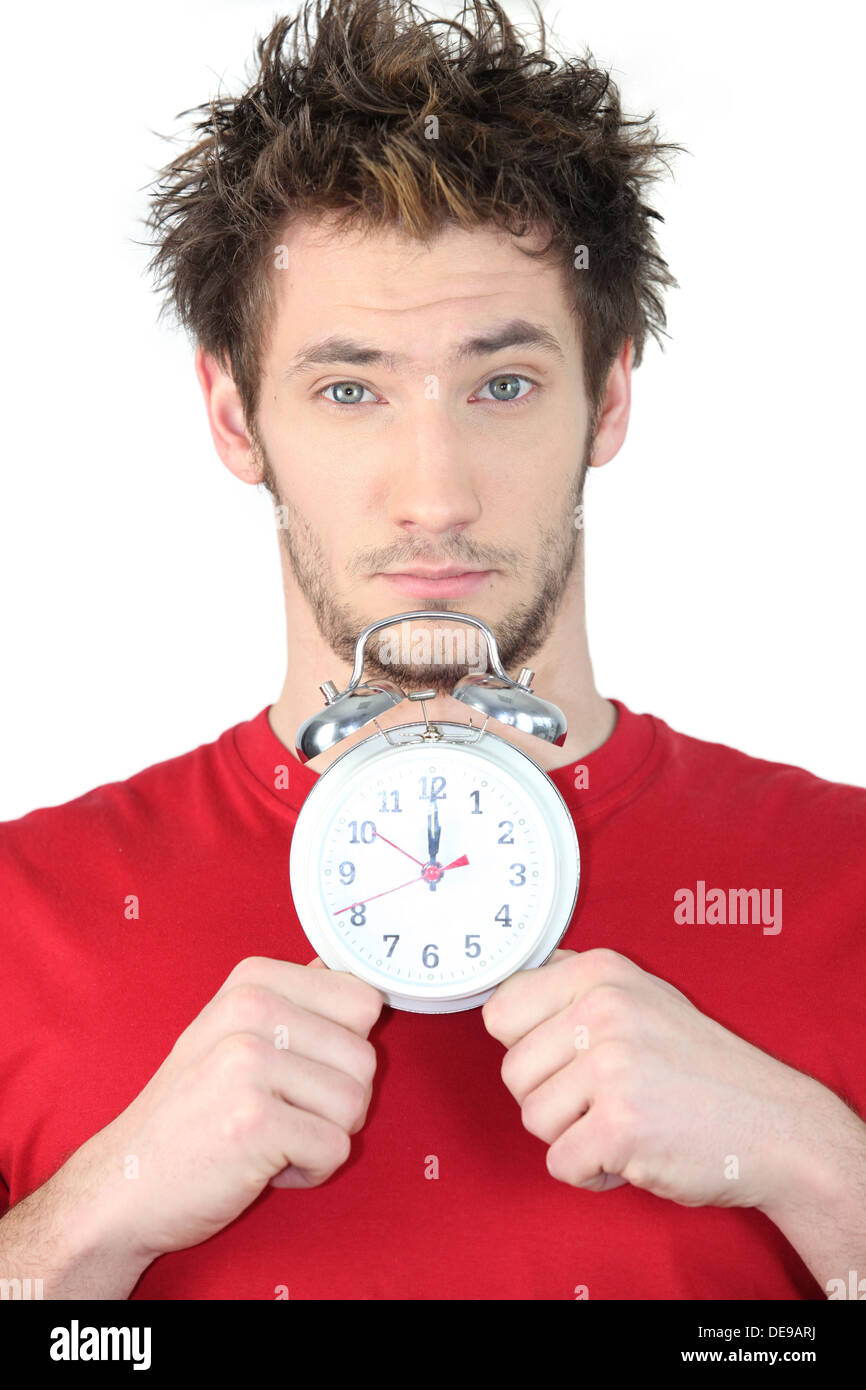 young guy with swollen eyes showing alarm clock Stock Photo - Alamy
