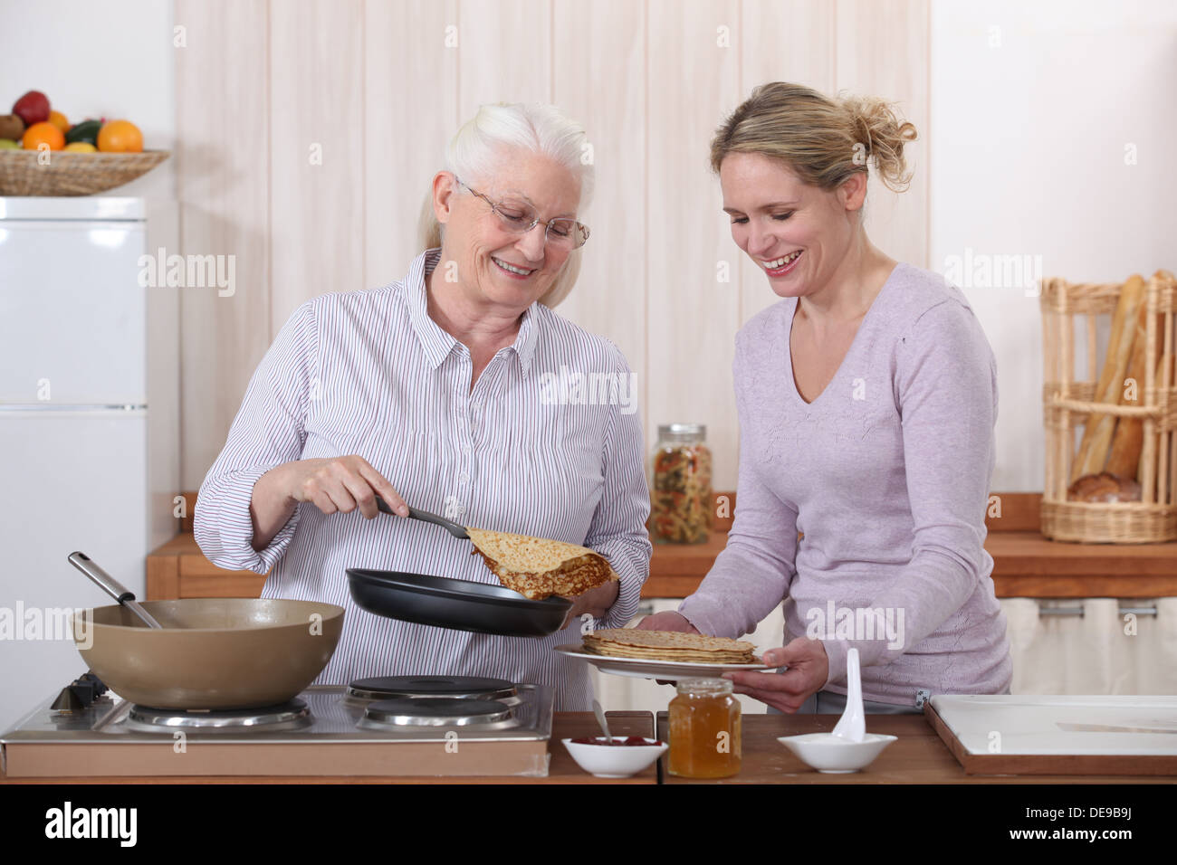 Mother and daughter cooking crepes Stock Photo - Alamy