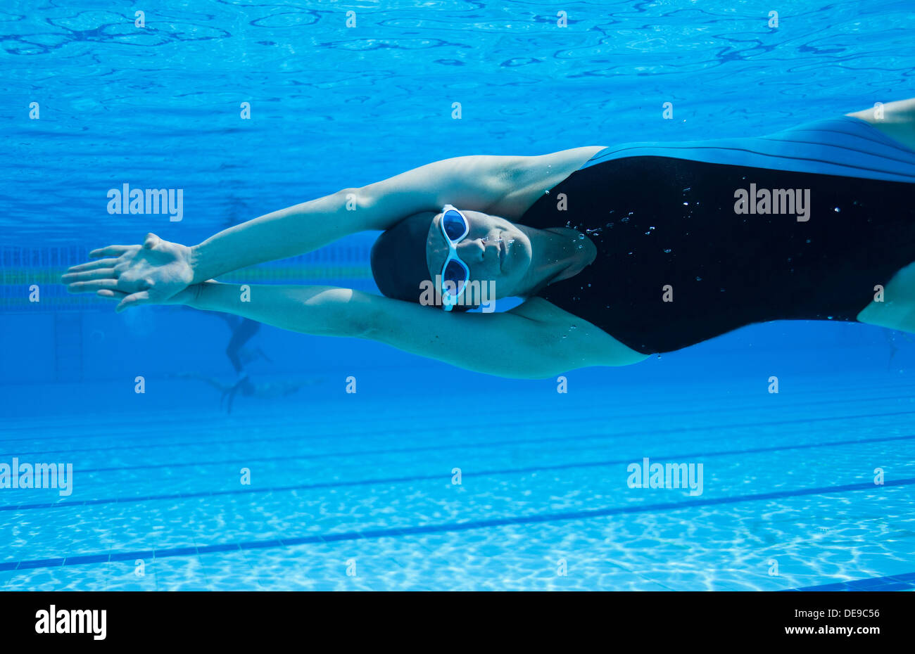 Female swimmer swimming in sideways position underwater in swimming ...