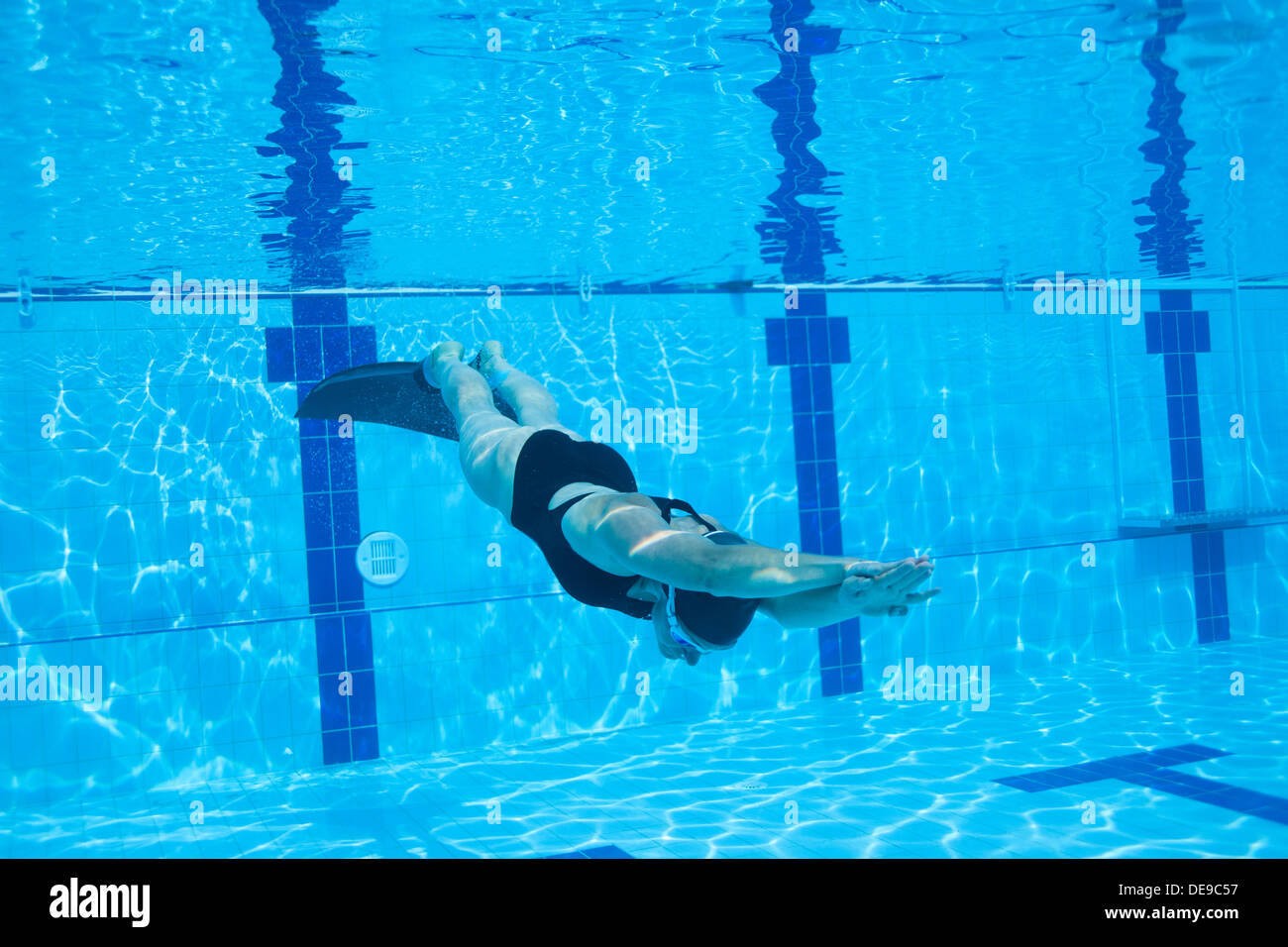 Female freediver with monofin swimming underwater in swimming pool ...