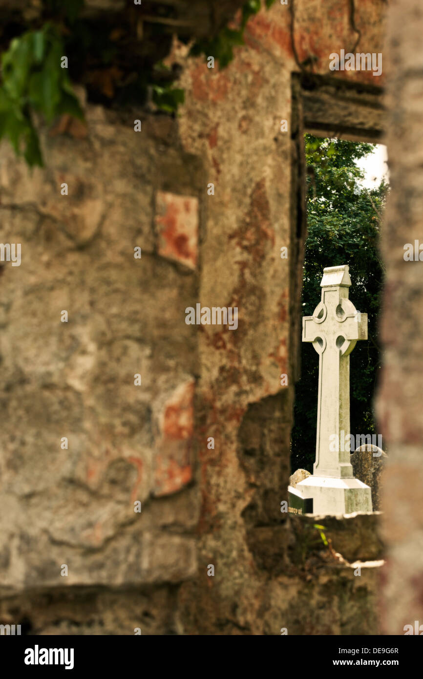 Celtic cross seen through the window of the ruins of the church at ...