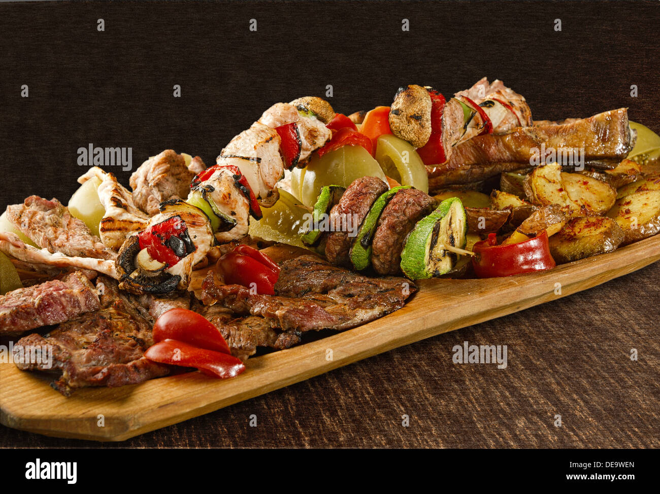 Rustic tray with various meats, mushrooms and assorted vegetables ...
