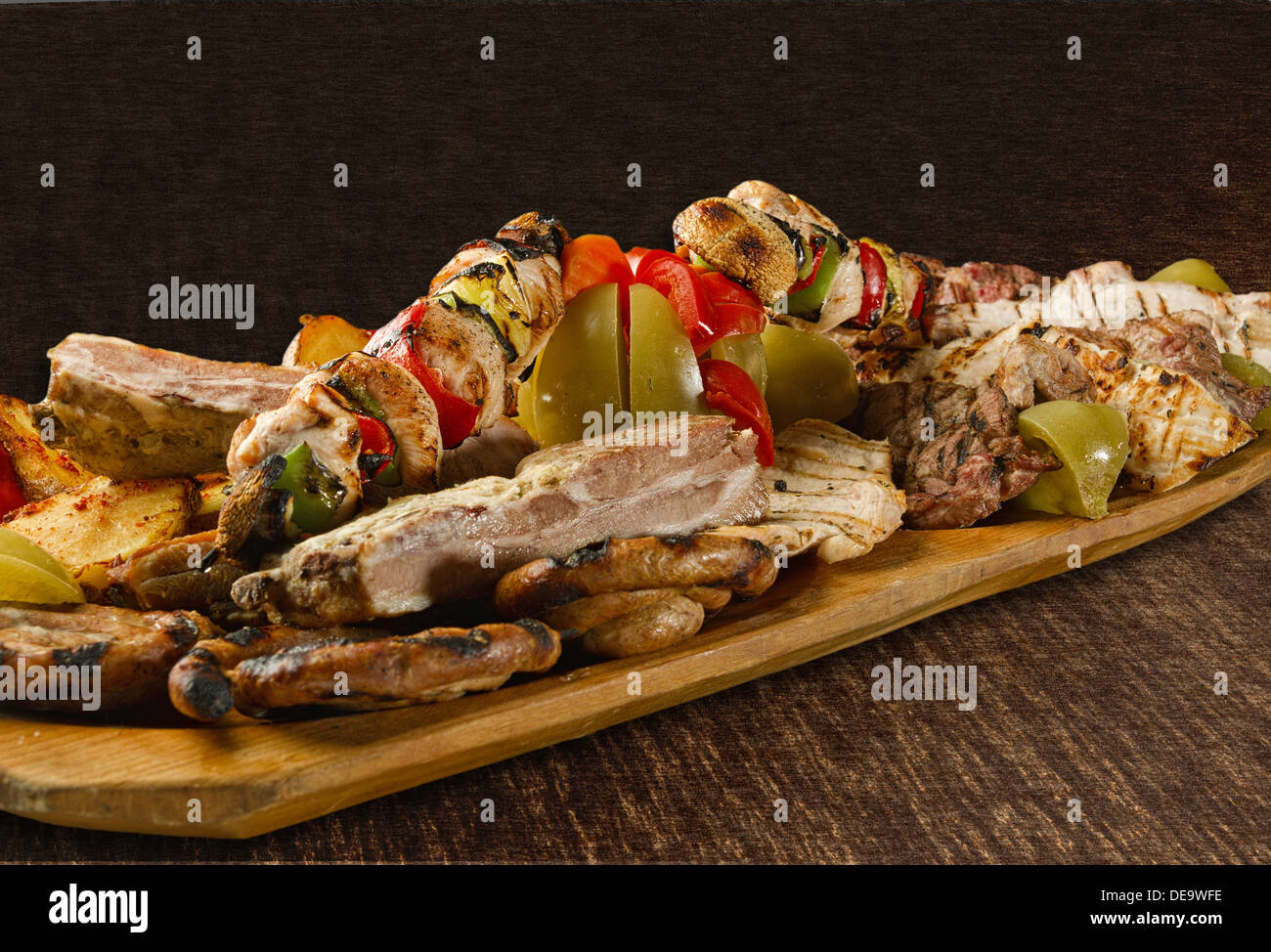 Rustic tray with various meats, mushrooms and assorted vegetables ...