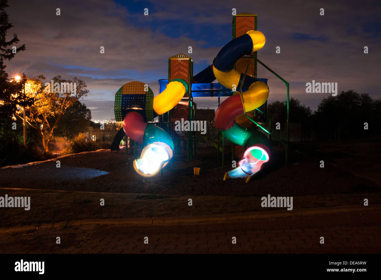 A slide at a playground lit from inside at night Stock Photo - Alamy
