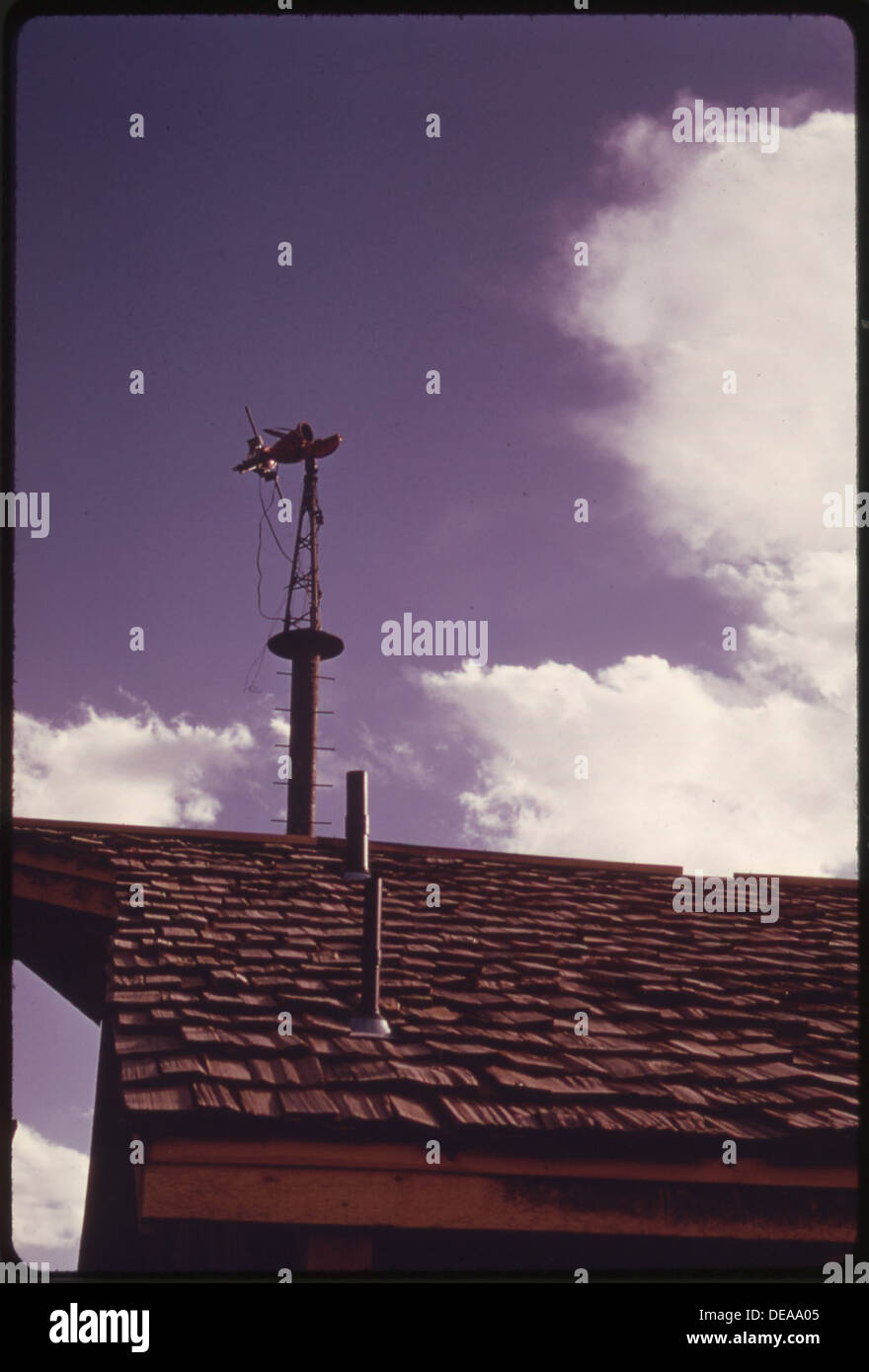 An electrical wind generator installed on the roof of a log house ...