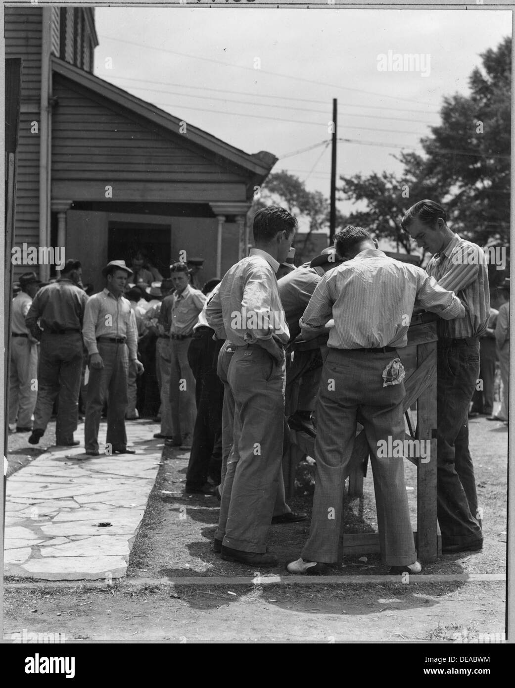 People wait in line outside a contractor's office in Coosa Valley ...