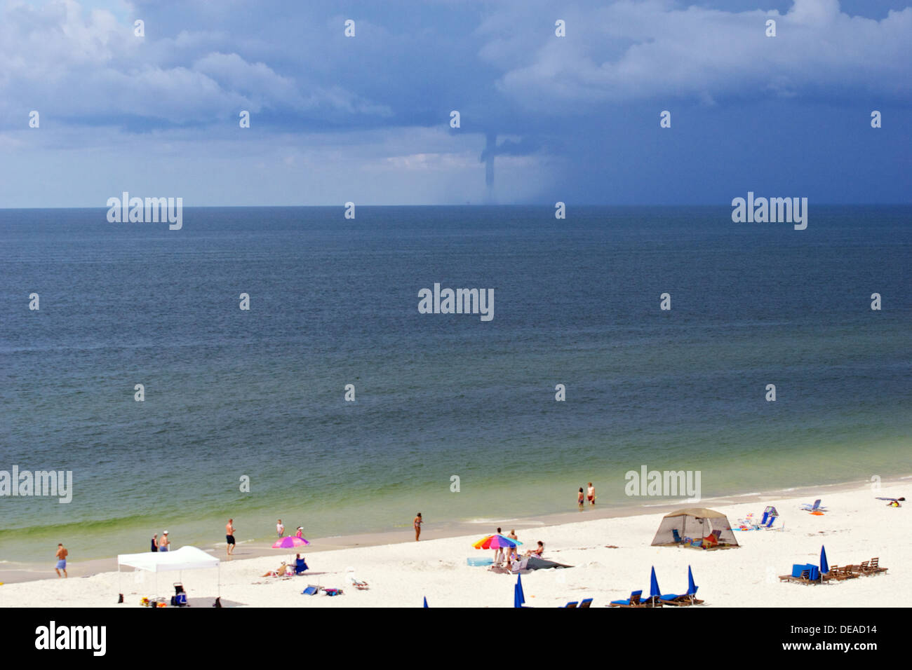 water cyclone forming in the Atlantic ocean with people on beach ...