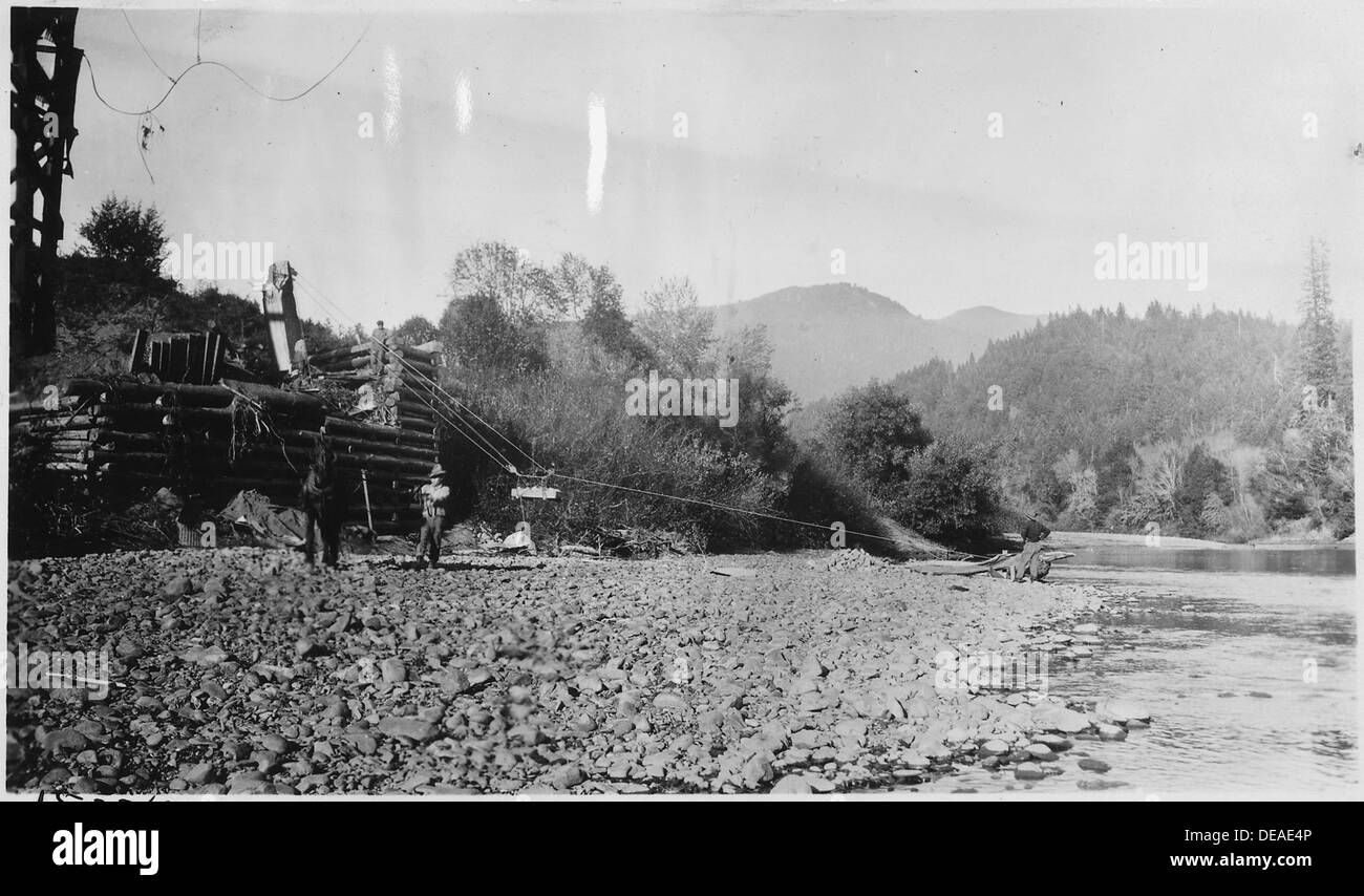 This image shows workers hauling rock from the river bank to the ...