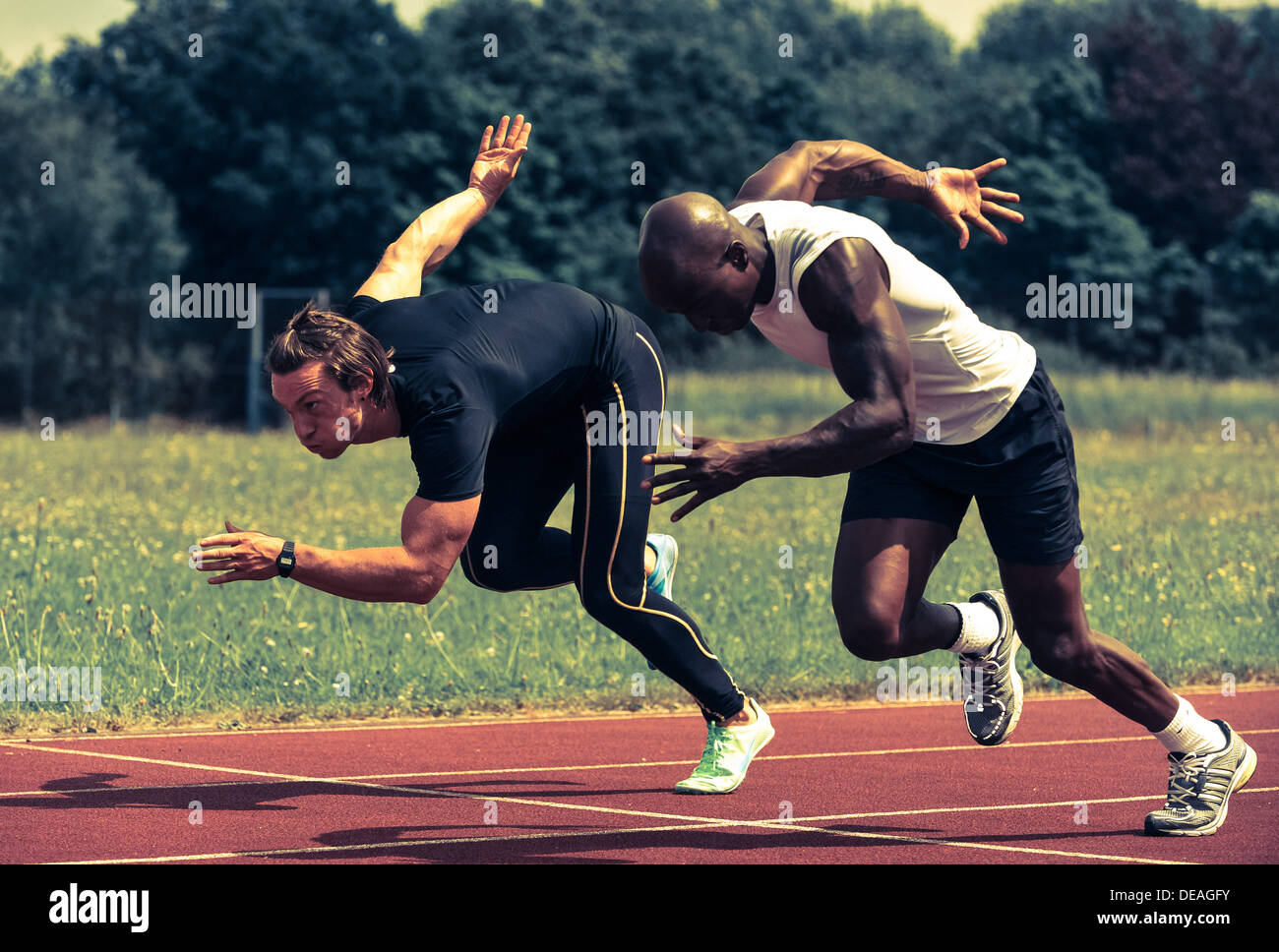 White and black male racing on running track Stock Photo - Alamy