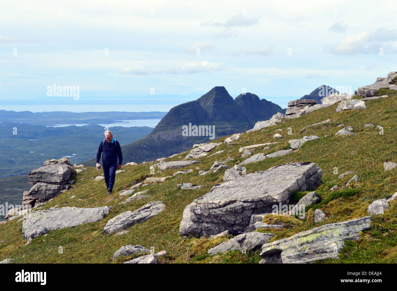 Lone hill walker heading down the Scottish Mountain Canisp (a Corbett ...