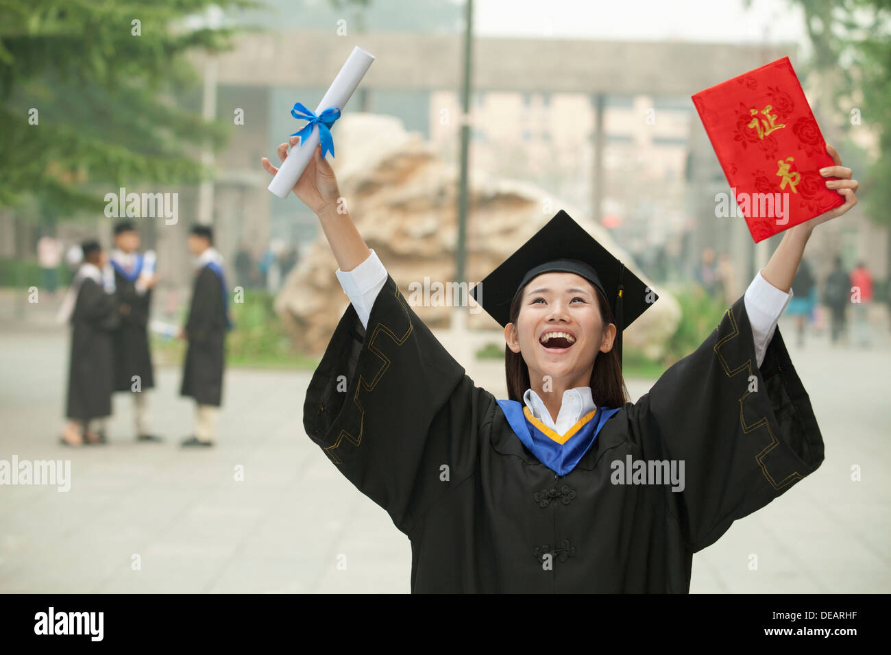 Young Female University Graduate, Arms Raised in the Air with Diploma ...