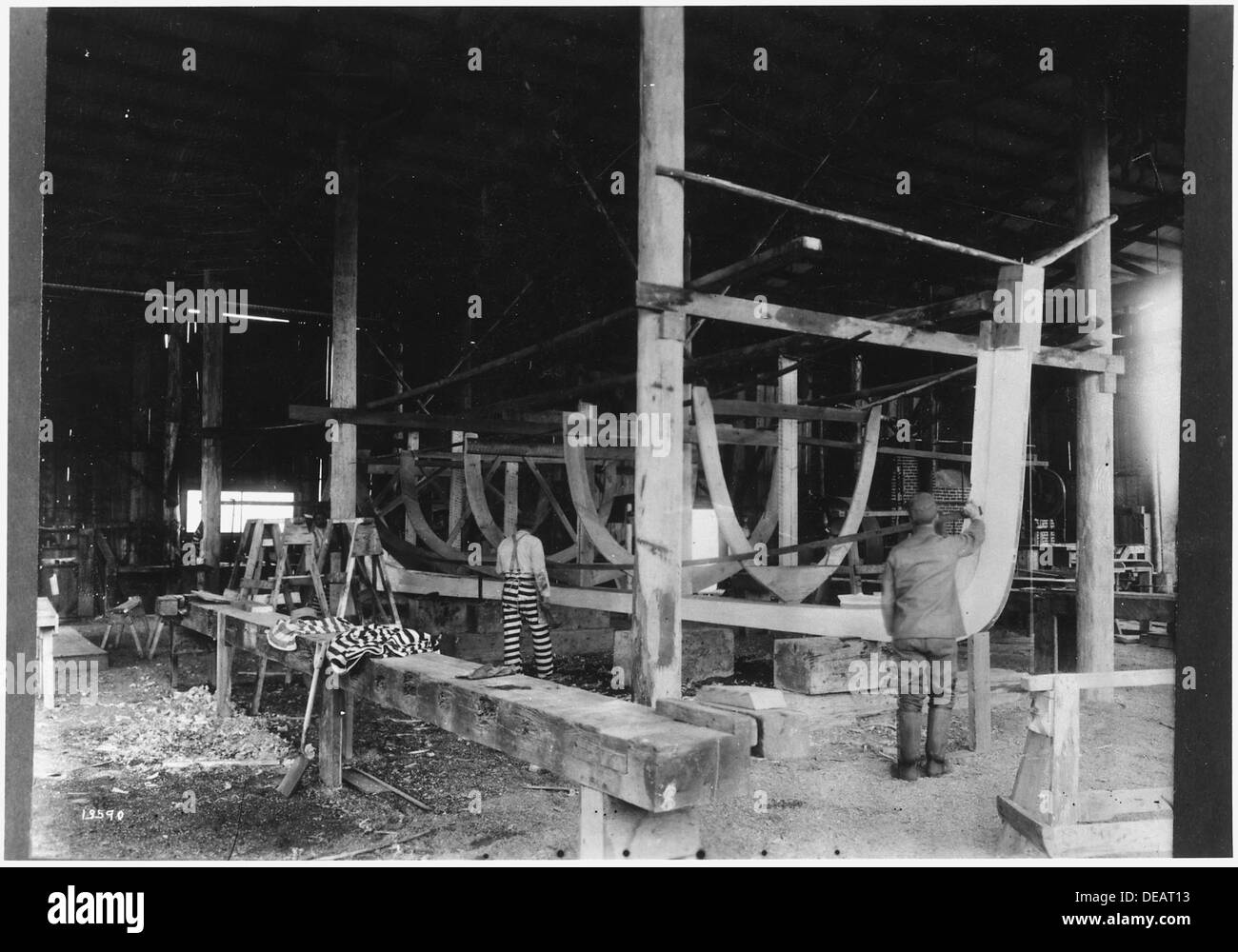This image depicts prisoners working inside a boathouse, providing a ...
