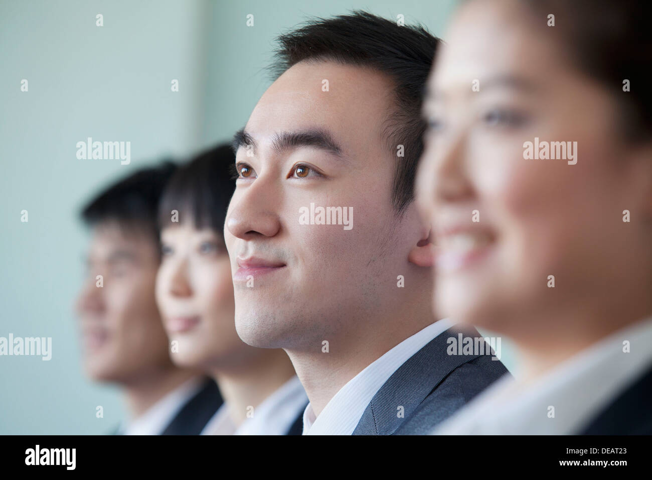 Four Business people sitting in a row, portrait Stock Photo - Alamy