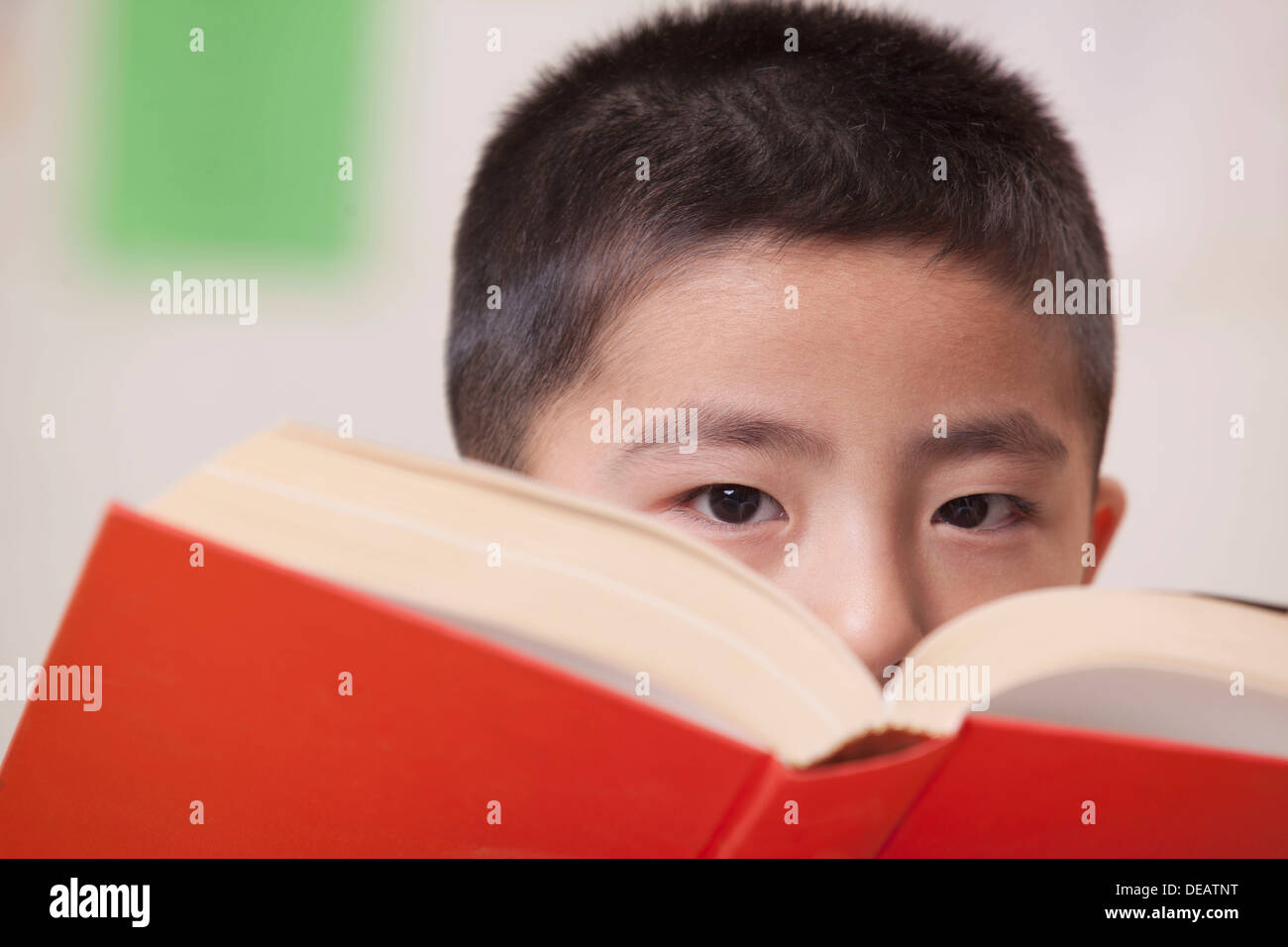 Boy Looking Over Book He's Reading Stock Photo - Alamy