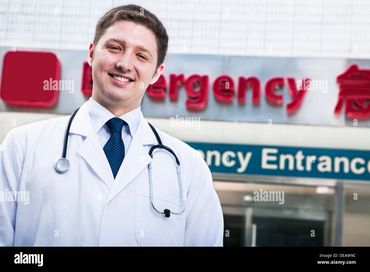 Portrait of young smiling doctor outside of the hospital, emergency ...