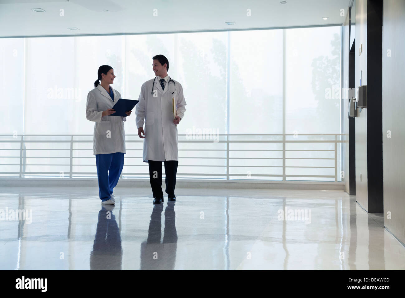 Two doctors walking and smiling in the hospital, full length Stock ...