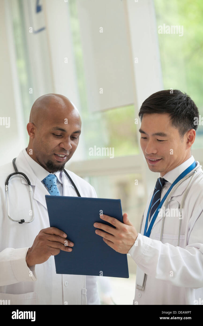 Two doctors looking down and consulting over medical record in the ...