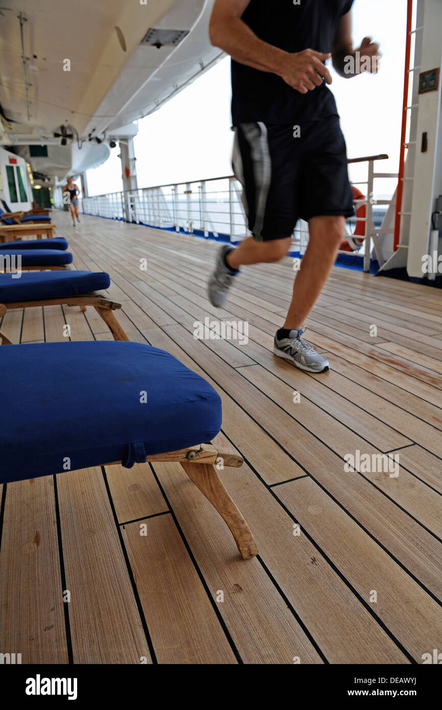 Passengers on a cruise ship taking their morning exercise along the ...