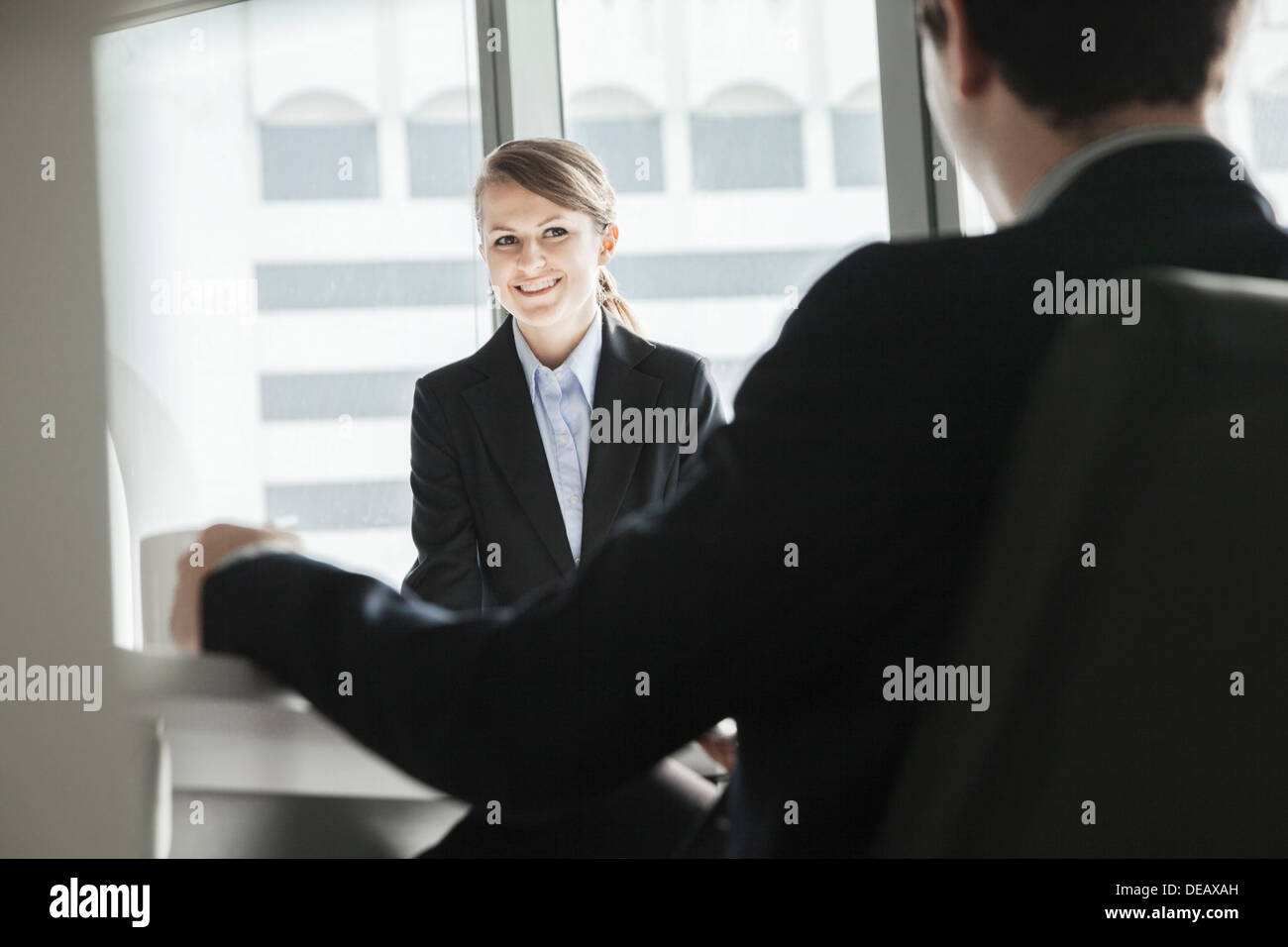 Two business people sitting, smiling and looking at each other during a ...