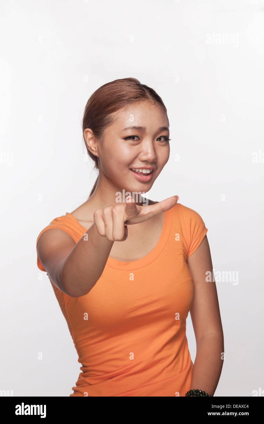 Portrait of teenage girl making hand sign at camera, studio shot Stock ...