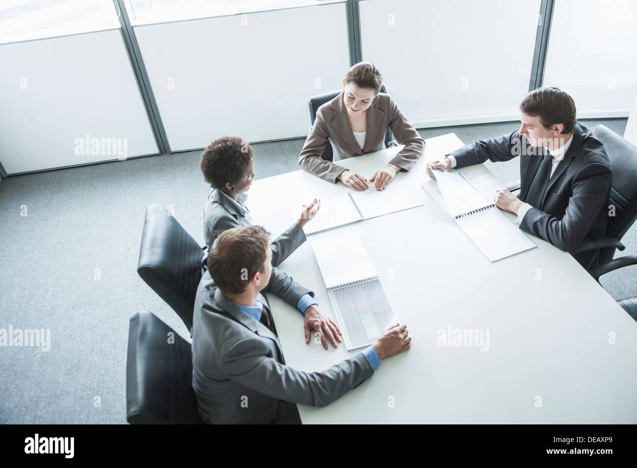 Four business people sitting around a table and having a business ...