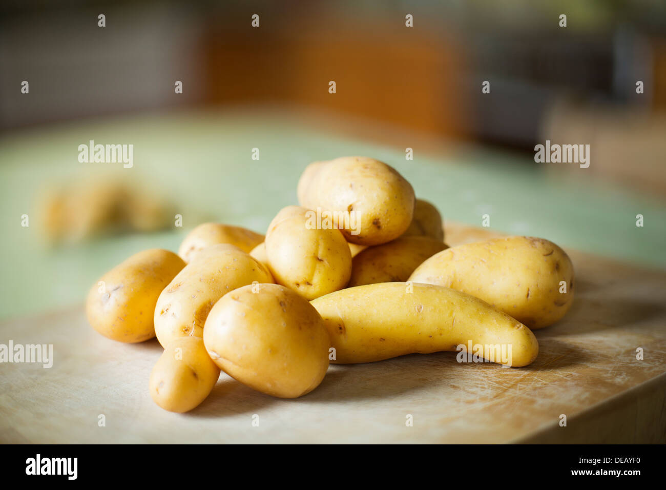Potatoes on a chopping board Stock Photo - Alamy