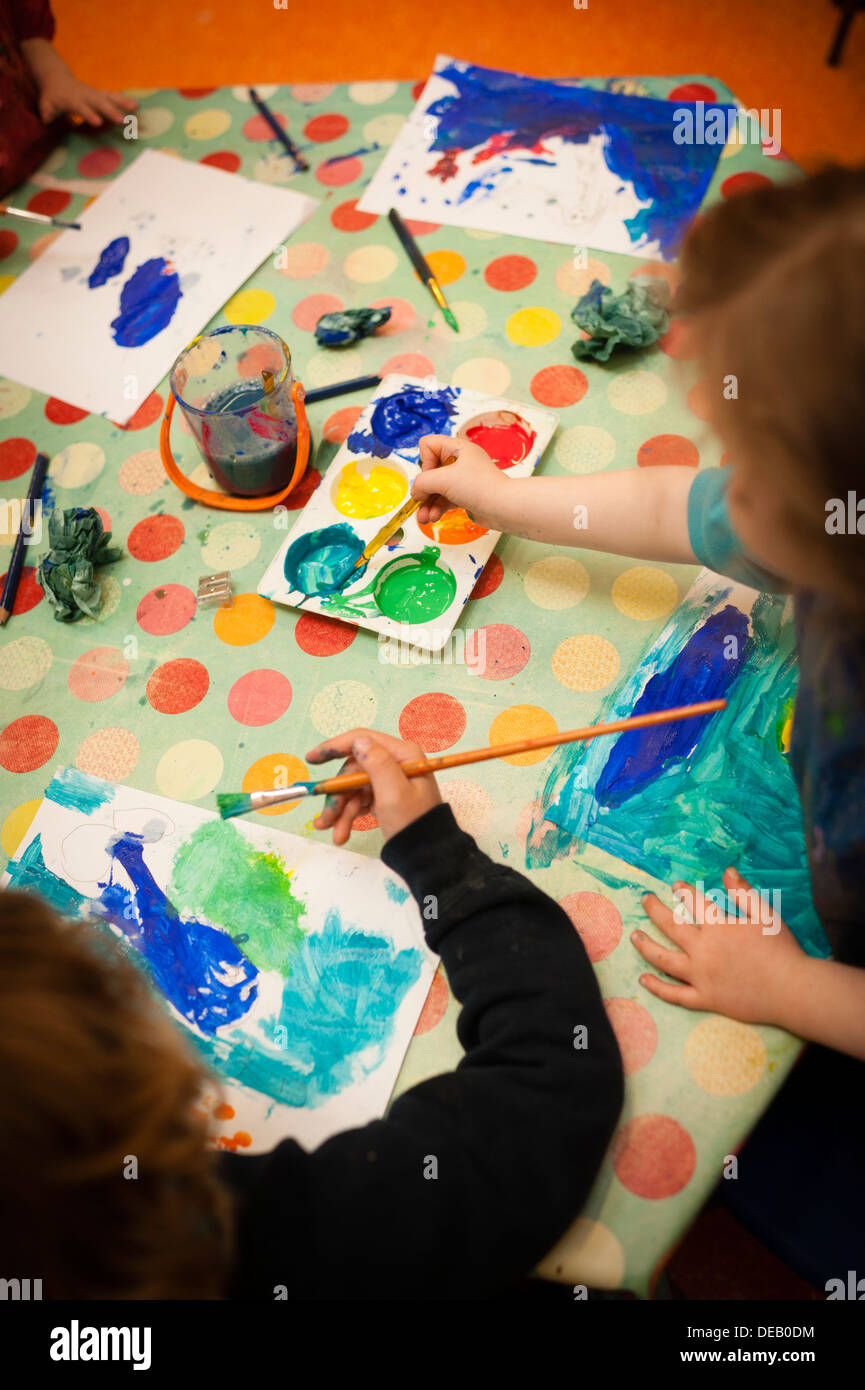 Pupils painting in an art class lesson in a primary school, Wales UK ...