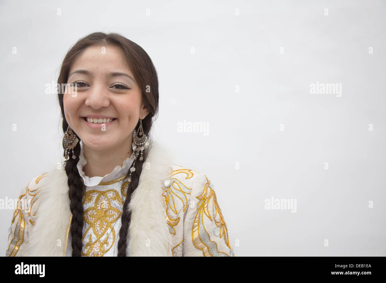 Portrait of young smiling woman with braids in traditional clothing ...