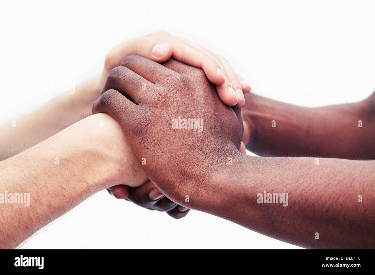 Two young men clasping each others hands, close-up, studio shot Stock ...