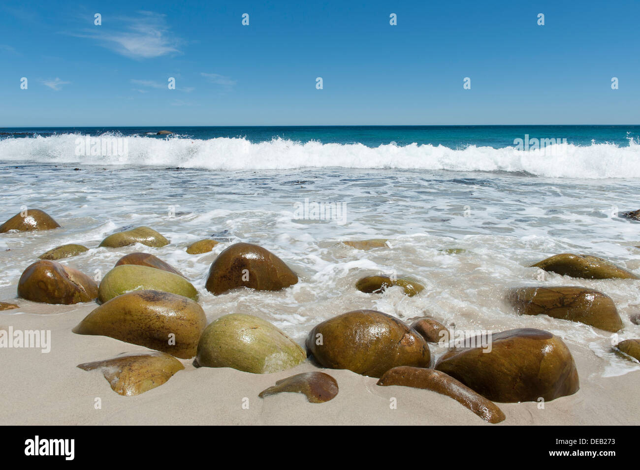 Beach with rocks polished smooth by the sea ocean in the background ...