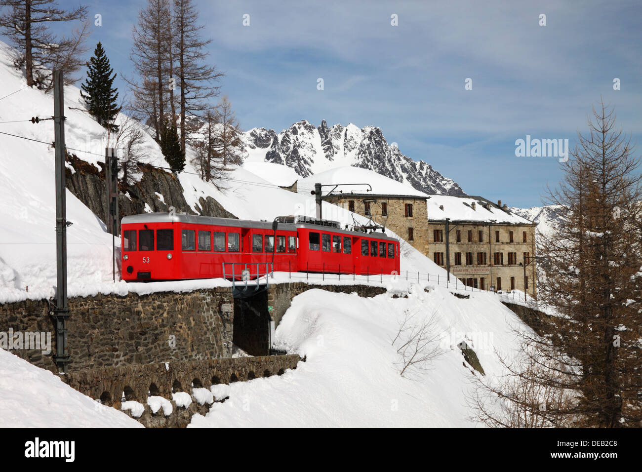 A red mountain train in snow covered mountains Stock Photo - Alamy