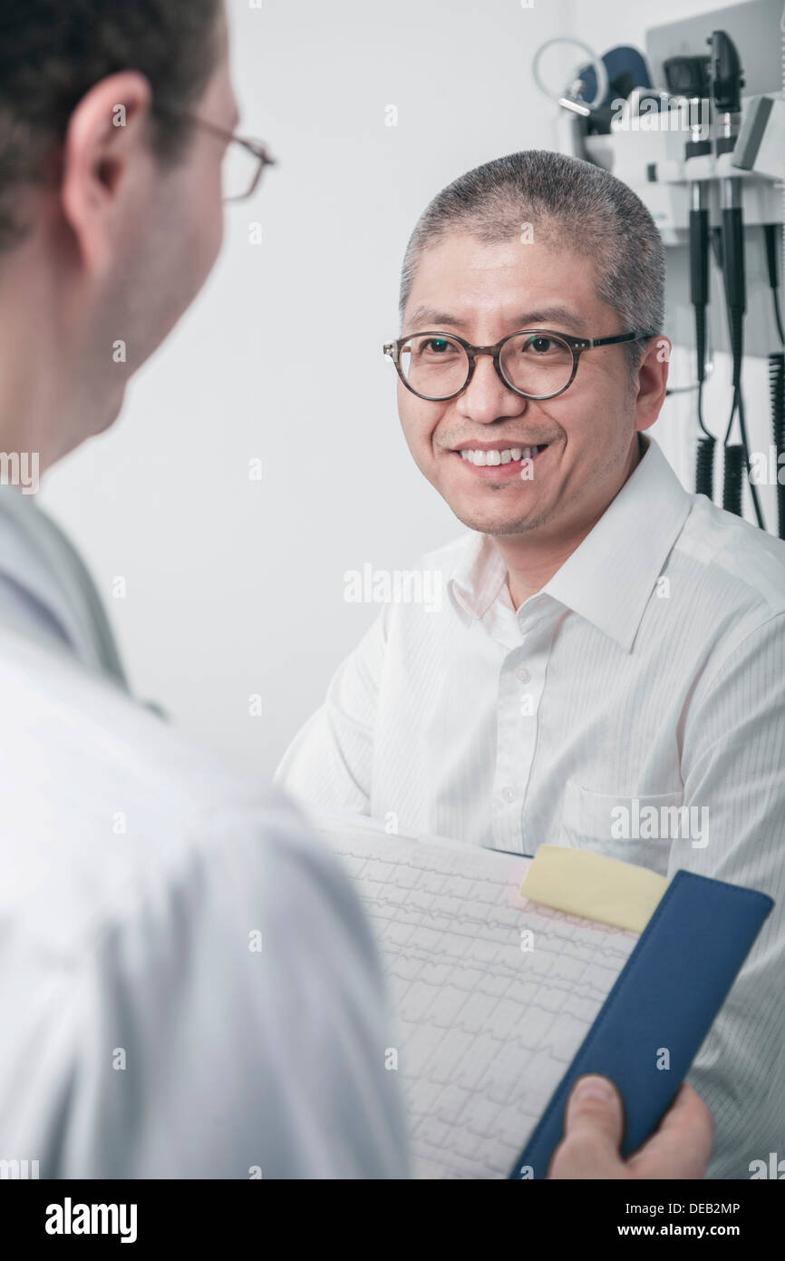 Doctor writing on patient chart hi-res stock photography and images - Alamy