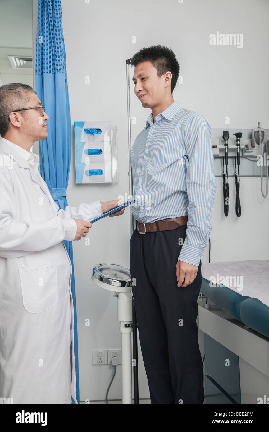 Doctor standing and facing a patient in the doctors office Stock Photo ...