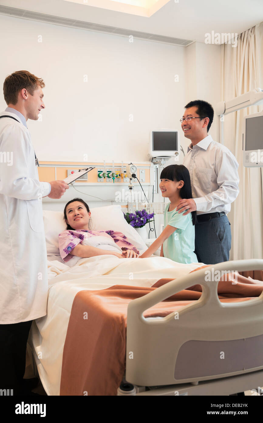 Family visiting the mother in the hospital, discussing with the doctor ...