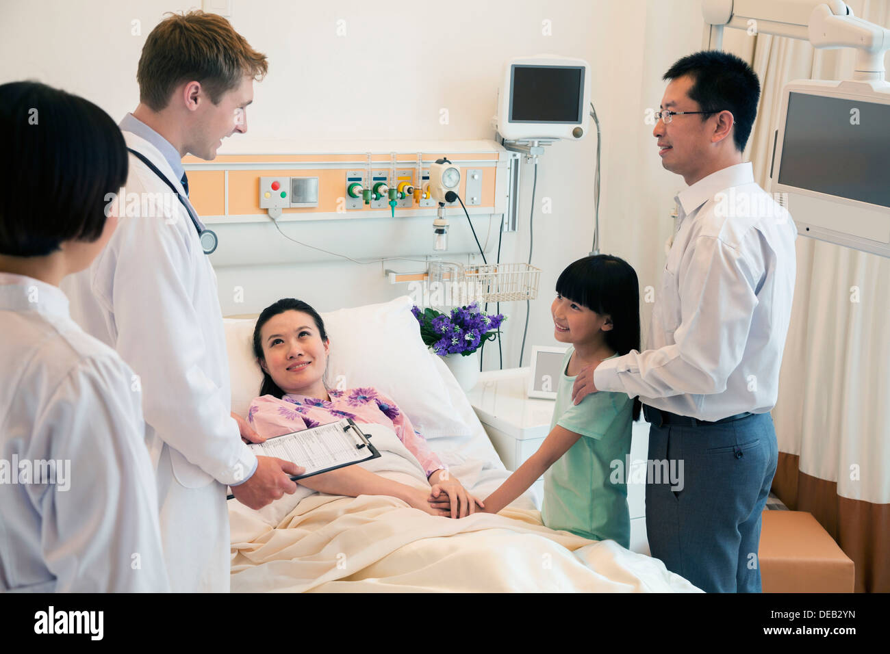 Family visiting the mother in the hospital, discussing with the doctor ...